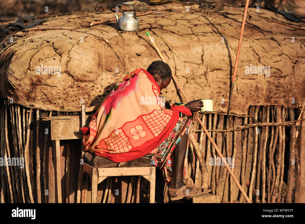Sunset in an African village - portrait of a brightly robed, Samburan ...