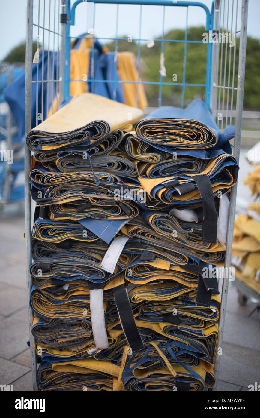 Tarpaulin market stall covers stored in a roll cage folded up and ready ...