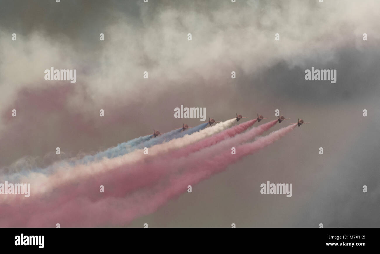 red arrows flying into stormy skies with smoke trails Stock Photo - Alamy
