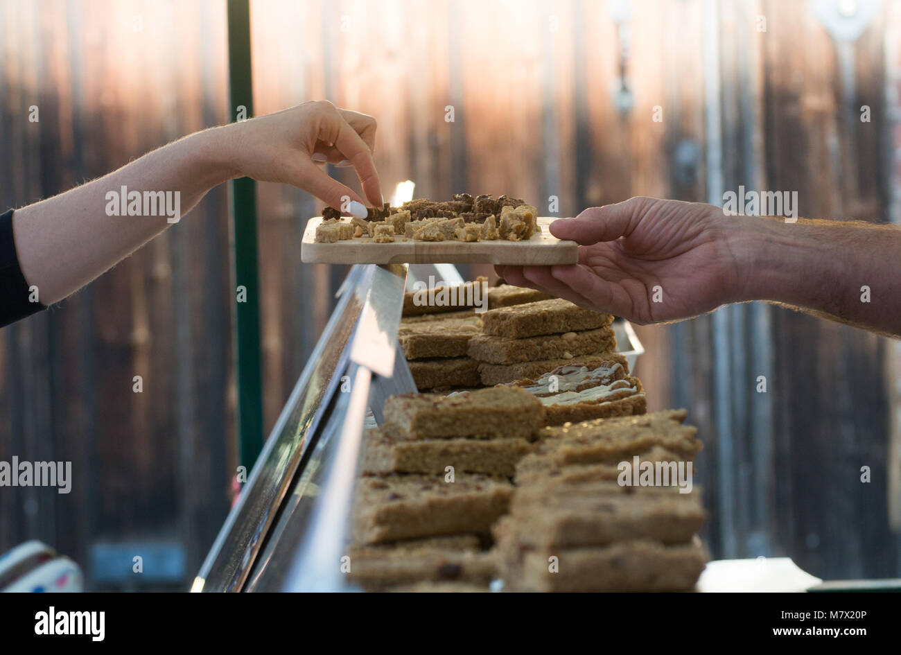 man offers sample of home baked biscuits and flapjacks from market ...