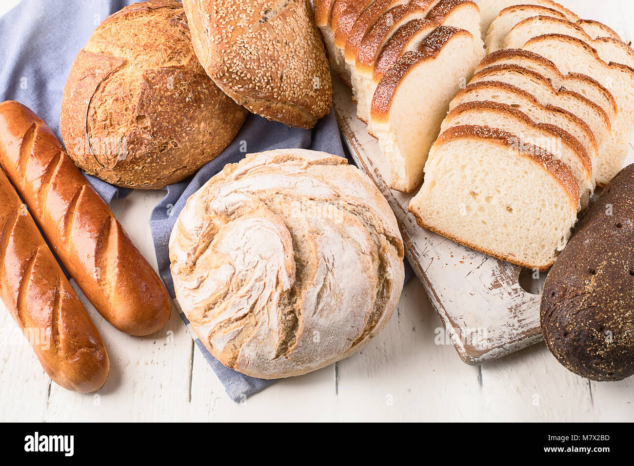 Mixed bread on white wooden table background. Top view Stock Photo - Alamy