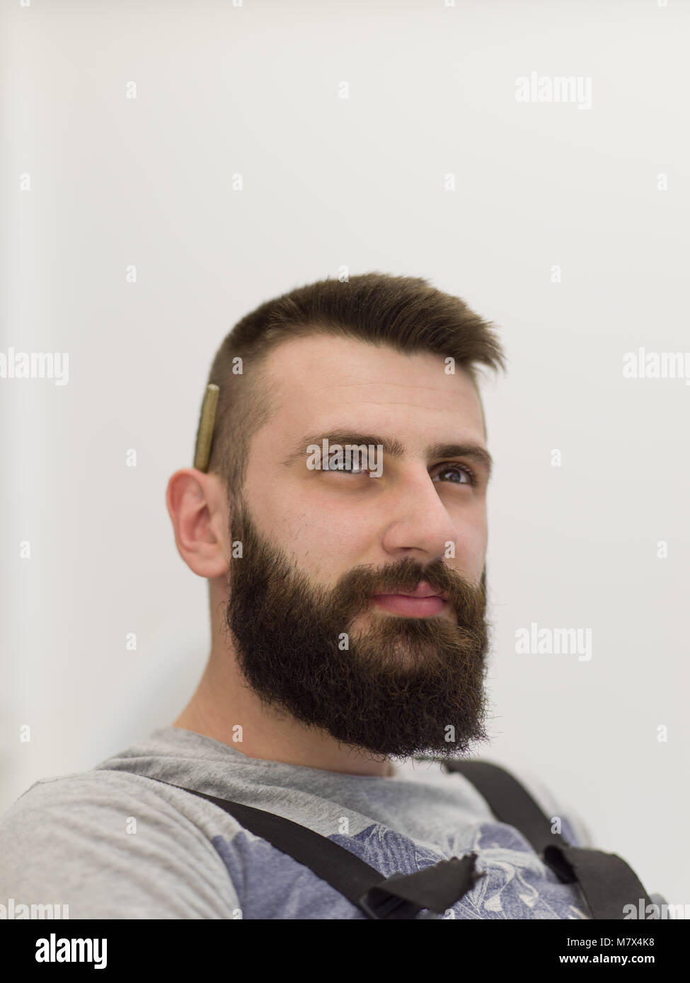 portrait of bearded hipster handyman with pen behind ear isolated on ...