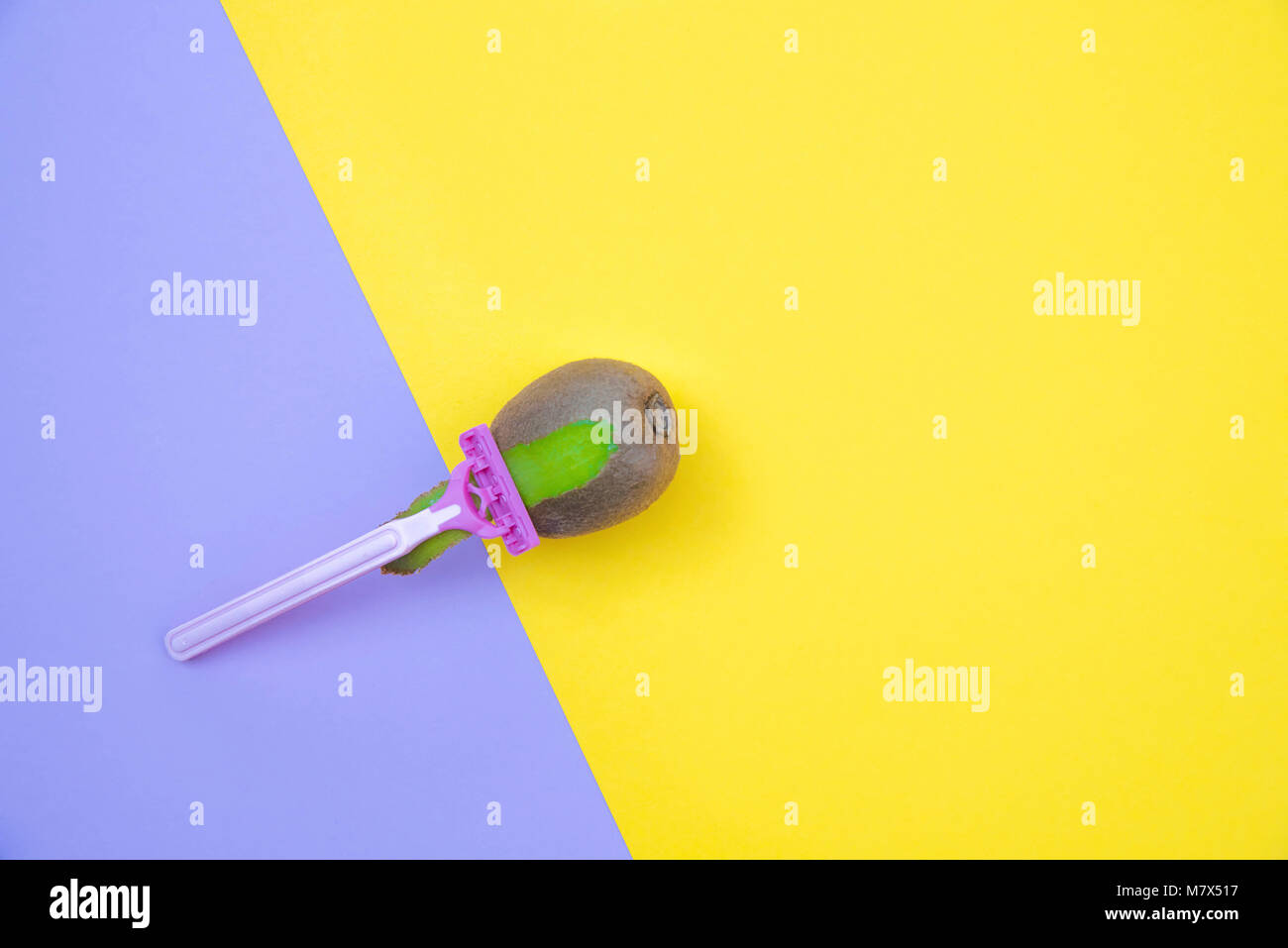 Kiwi fruit and razor on violet and yellow background. Hair removal ...