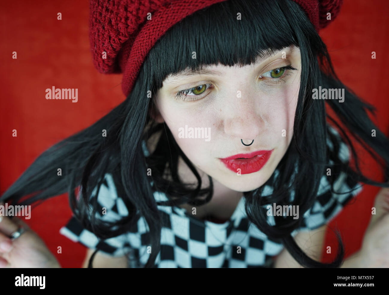 Cool young woman against red background Stock Photo - Alamy