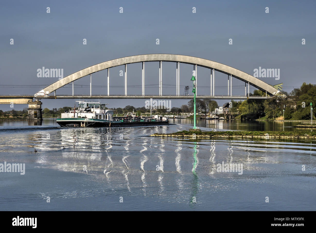 Inland barge passing under the railway bridge accross the river Lek in ...