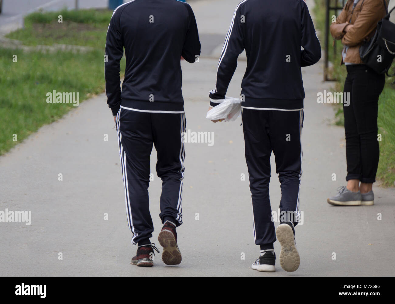 two of the same guy walking on the sidewalk Stock Photo - Alamy
