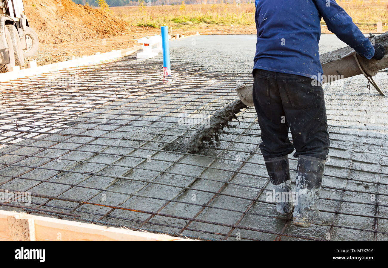 Closeup shot of concrete casting on reinforcing metal bars of floor in ...