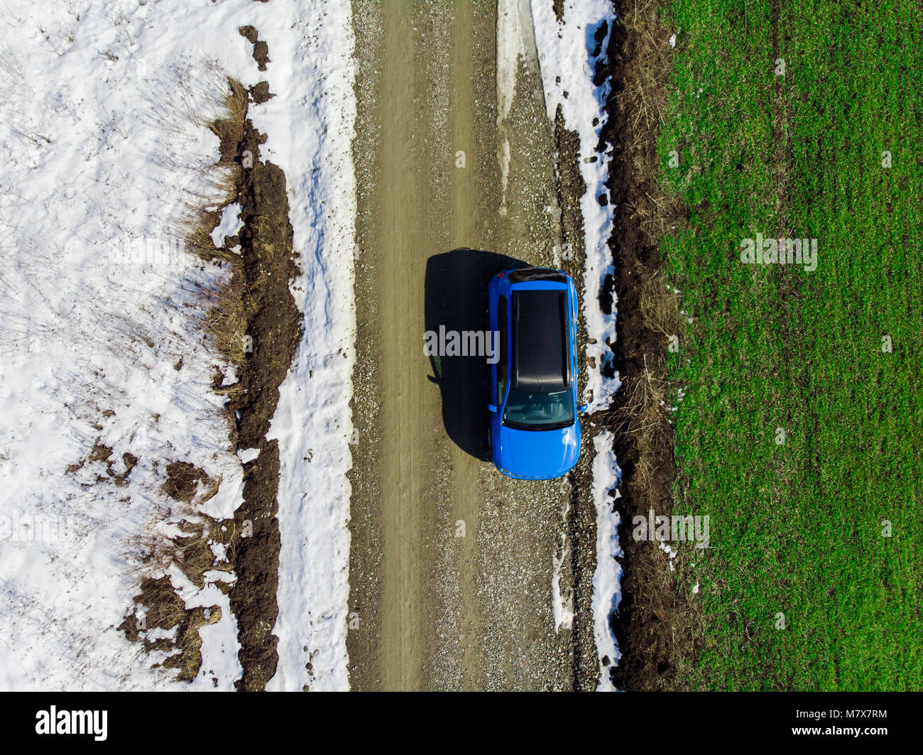 aerial view of blue car on the road. snow and green field Stock Photo ...