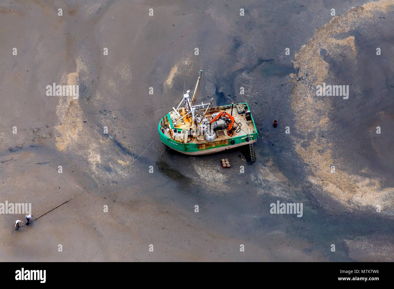 Controversial methods of Cockle fishing. Cockle boats at low tide in ...