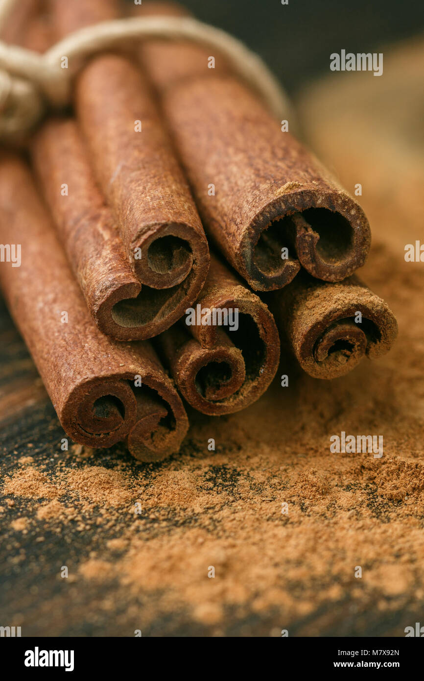 Cinnamon sticks and powder on rustic wooden Board closeup. Spices ...