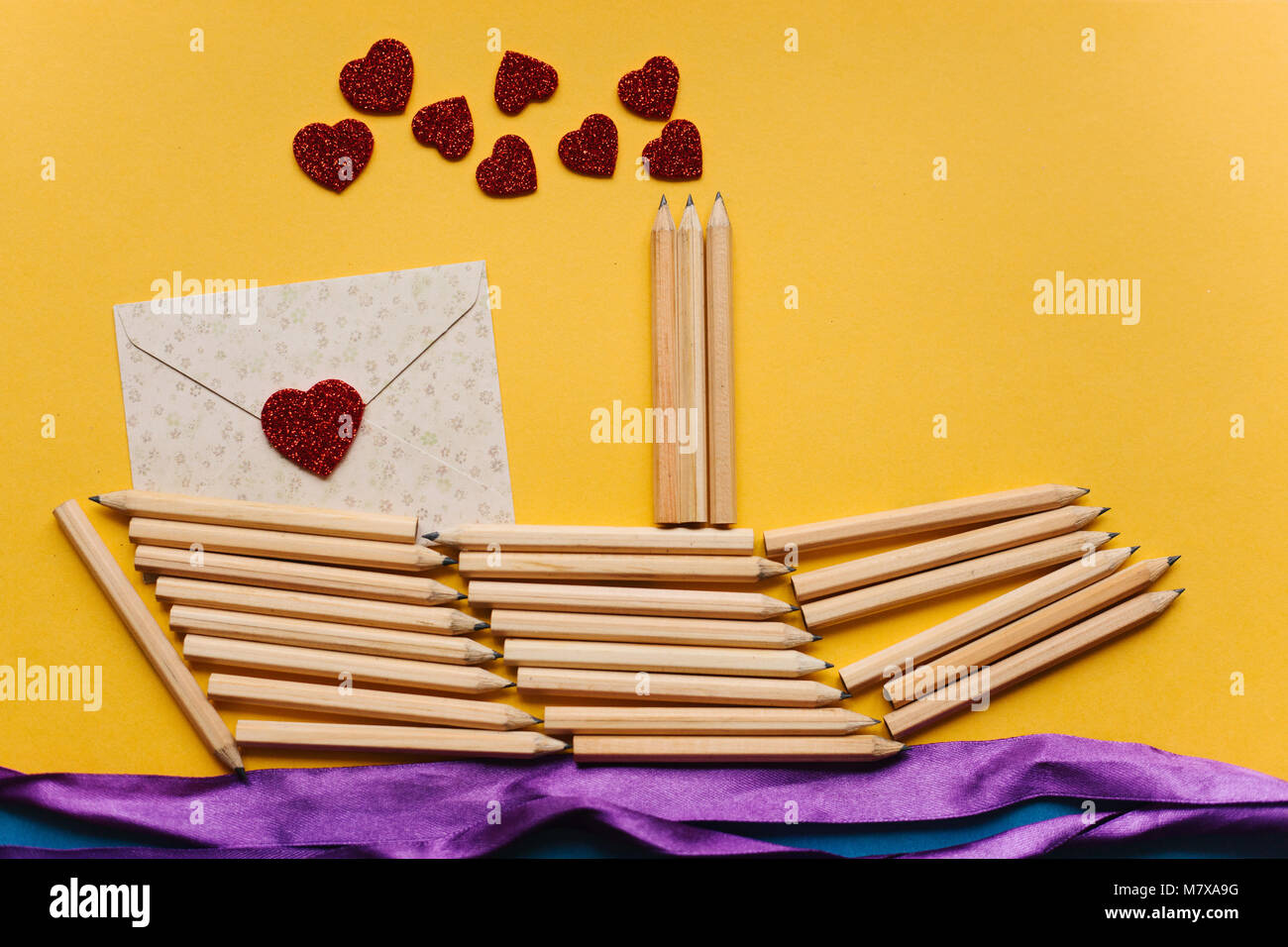 A pencil ship and a letter with a heart. Creative workplace. Preparing ...