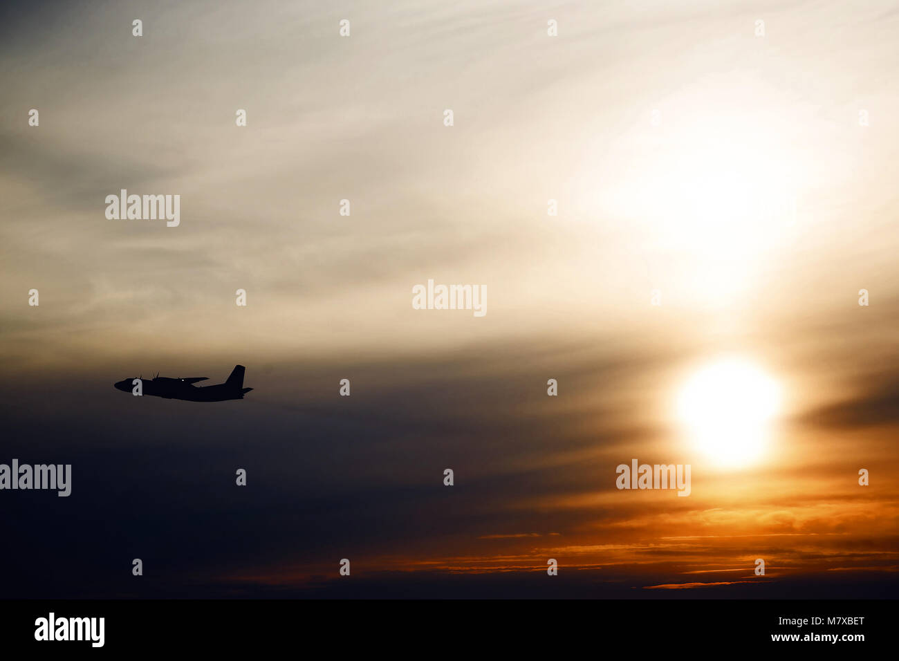 plane flying at sun in sunset sky. airplane in the air. transportation ...
