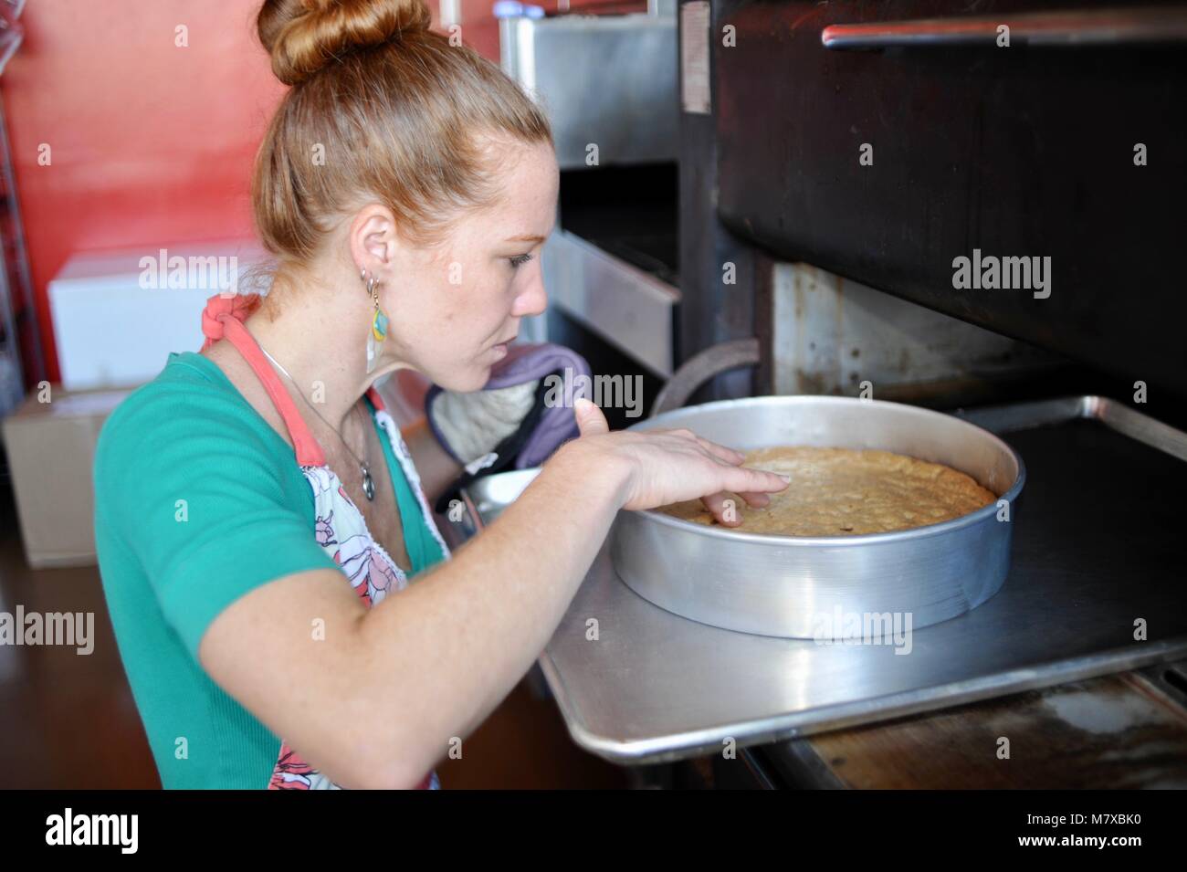 Woman baker working at her small commercial bakery kitchen in USA Stock ...
