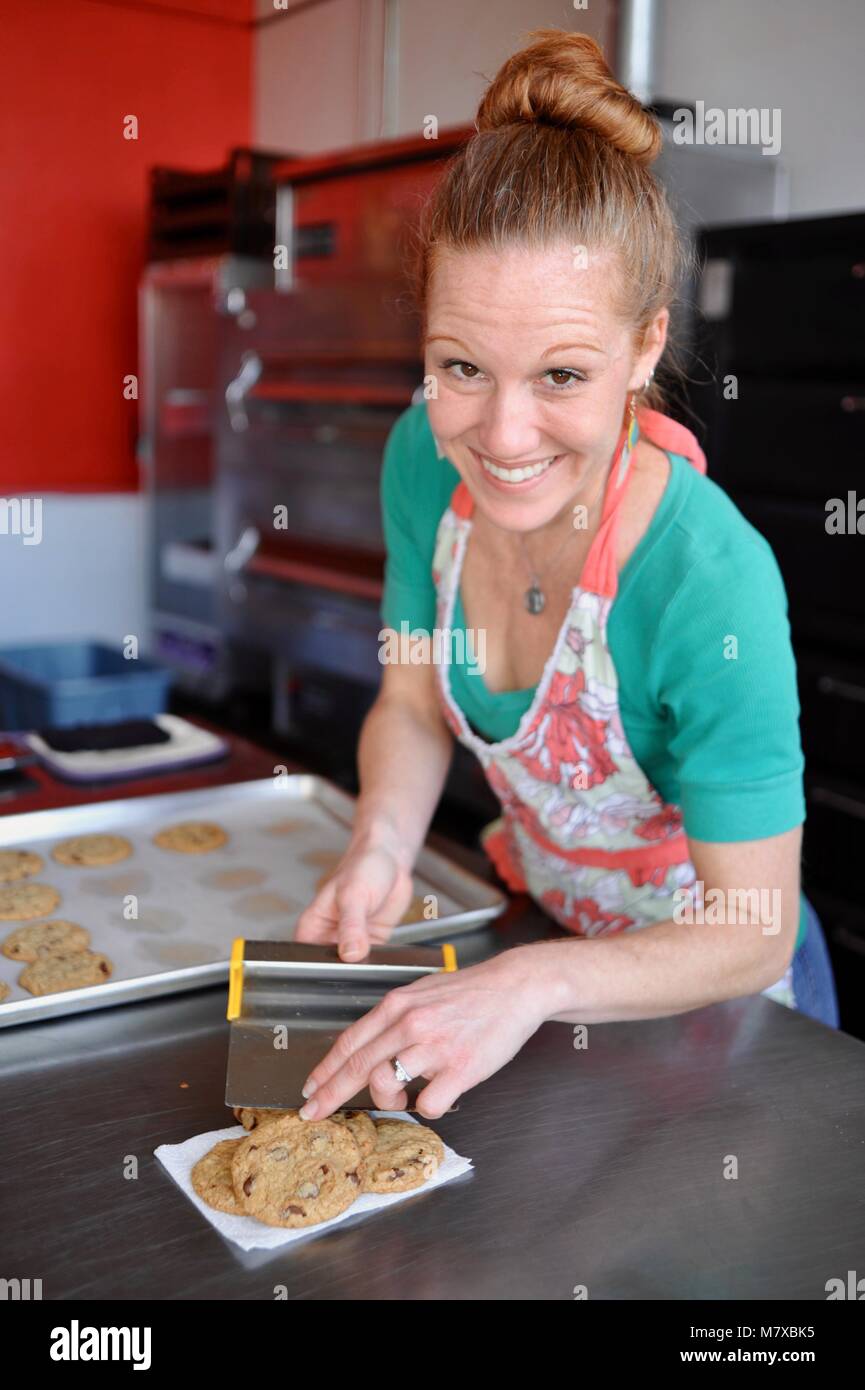 Woman baker working at her small commercial bakery kitchen in USA Stock ...
