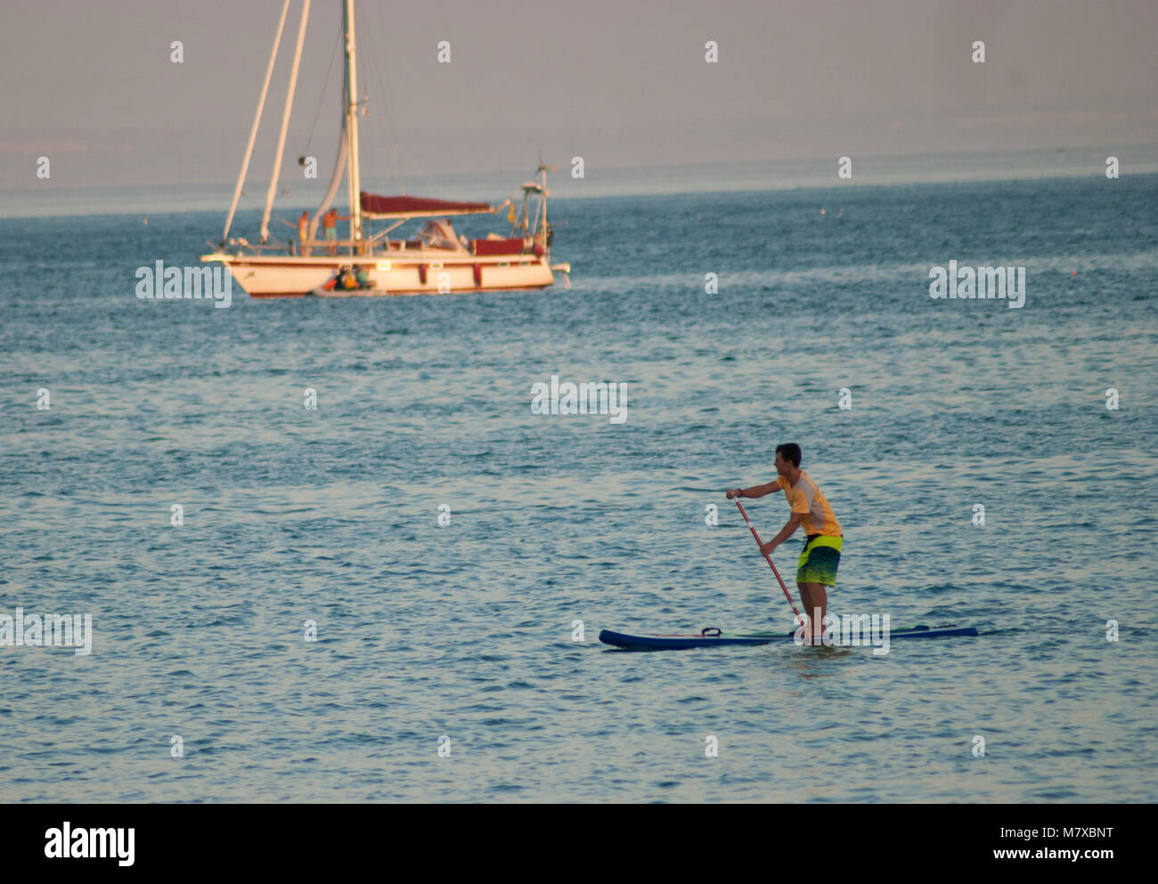 Paddle Boarding In The Sea With Boat Stock Photo - Alamy
