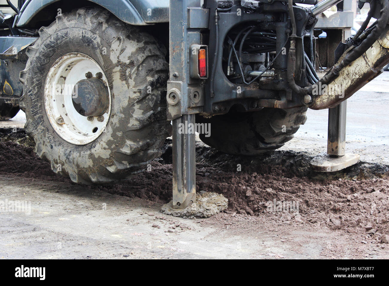 Tractor strong outrigger stabilizing legs extended to stabilize and ...