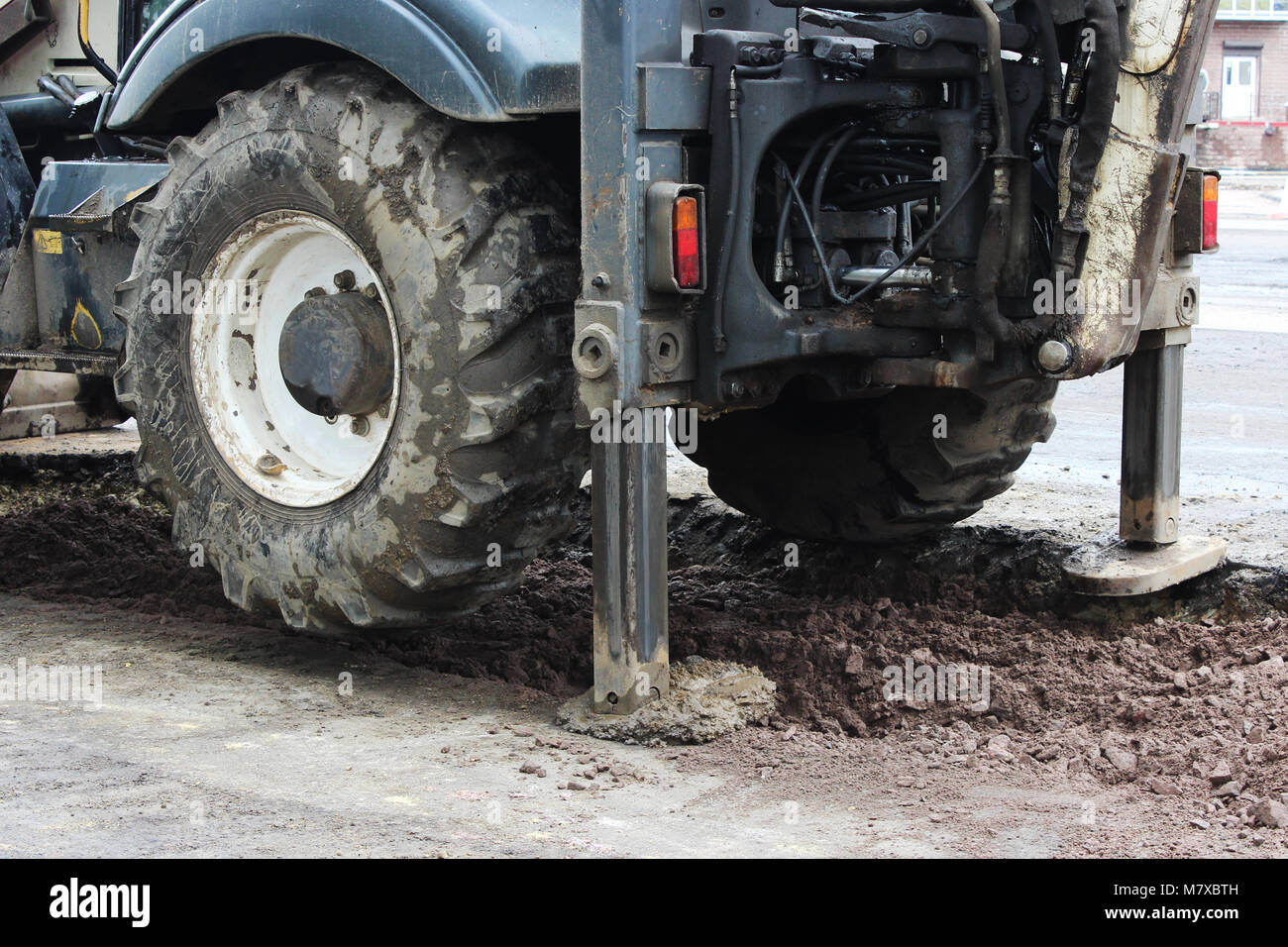 Tractor strong outrigger stabilizing legs extended to stabilize and ...