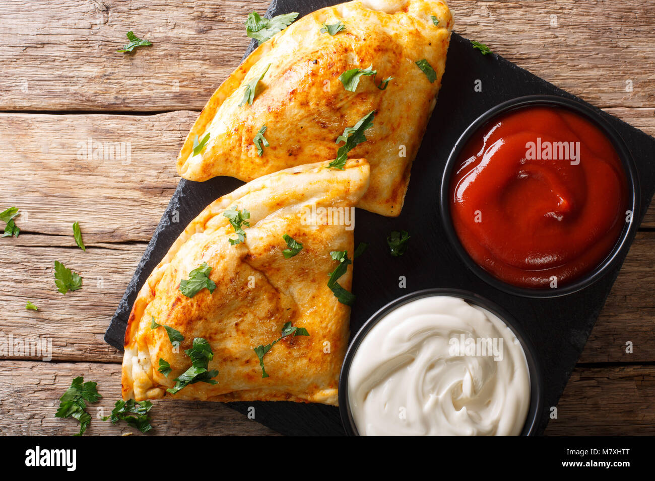 Italian food: pizza calzone with meat, vegetables and cheese close-up ...