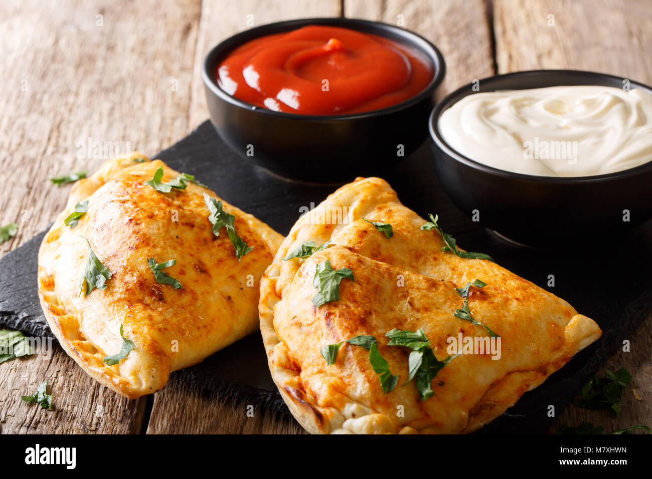 Italian food: pizza calzone with meat, vegetables and cheese close-up ...