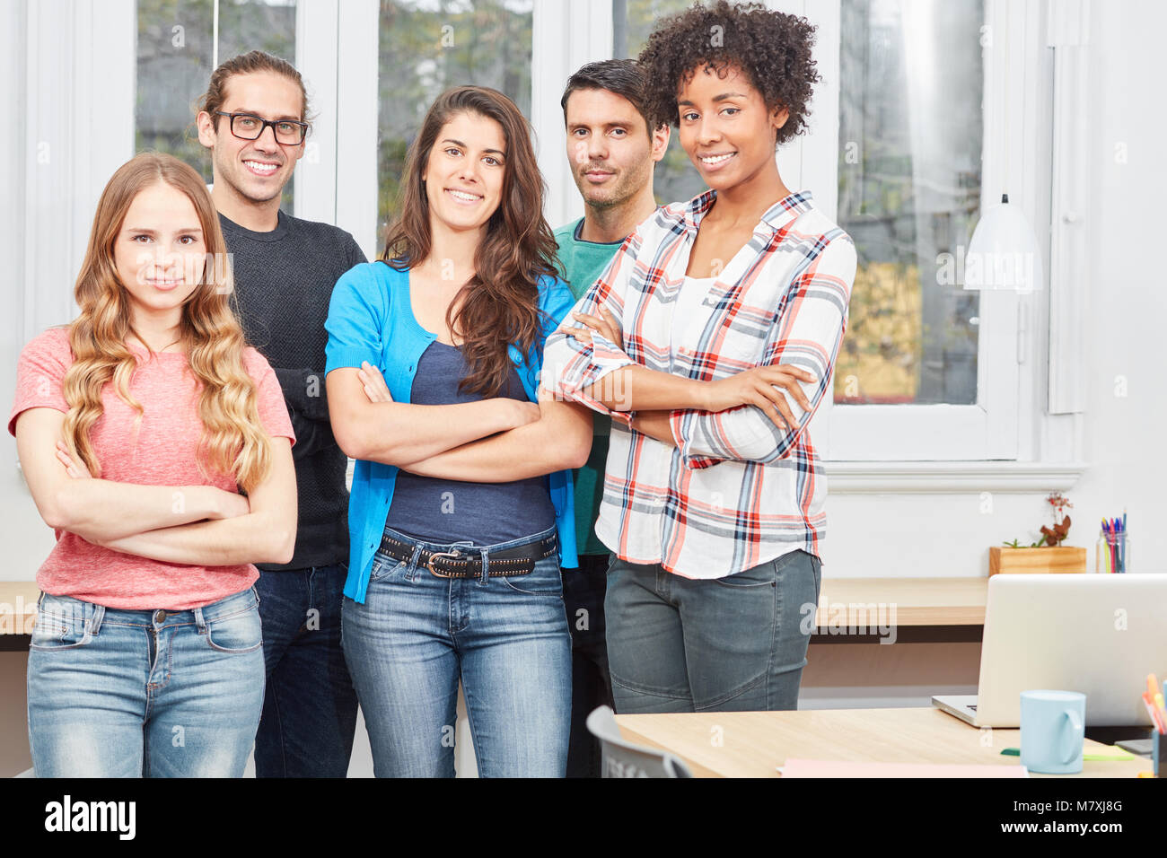 Students as young startups of a business start-up smile confidently in ...