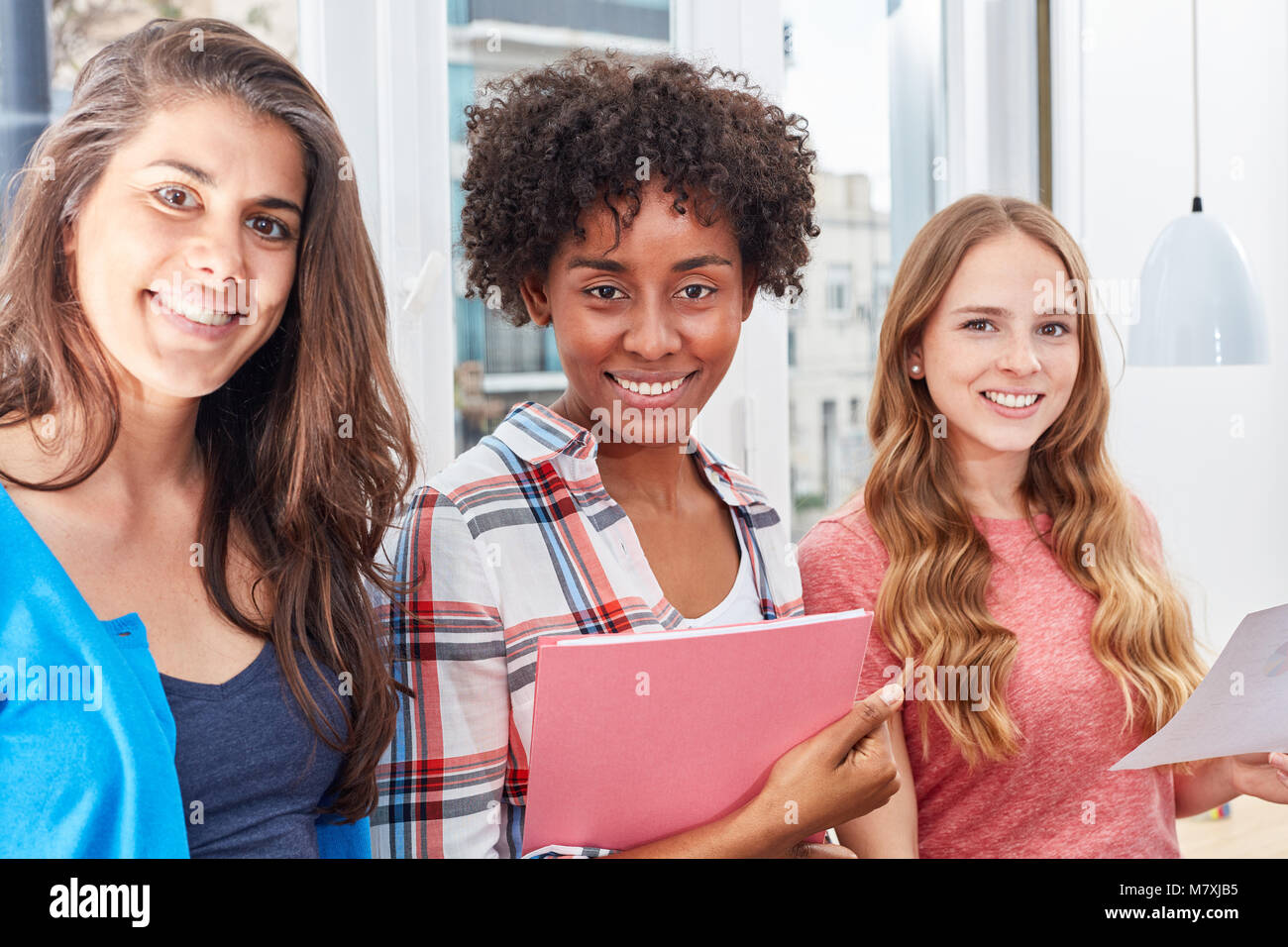 Three young women as students or trainees studying or internships Stock ...