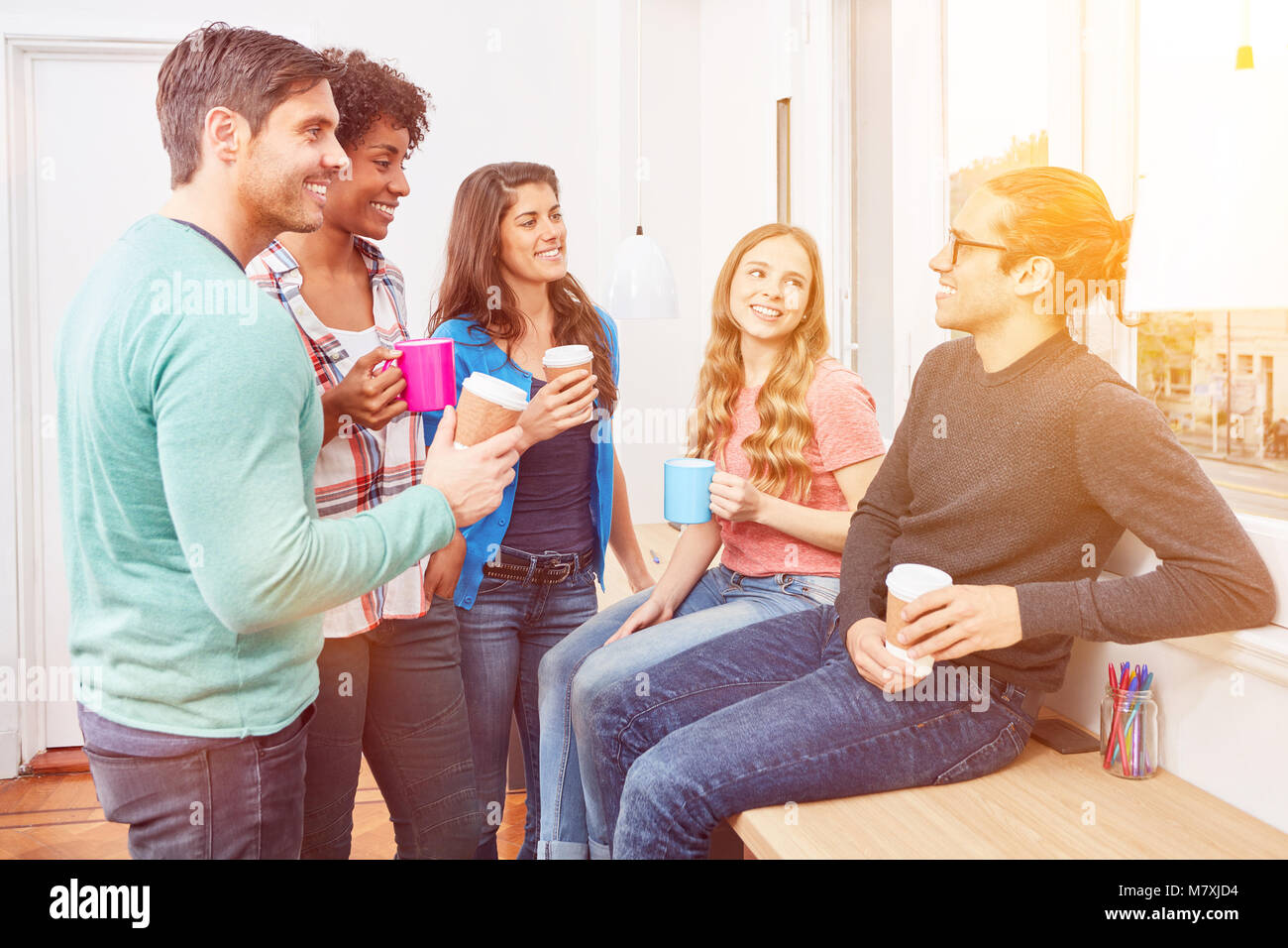 Group of smiling students in cafe having coffee in break Stock Photo ...