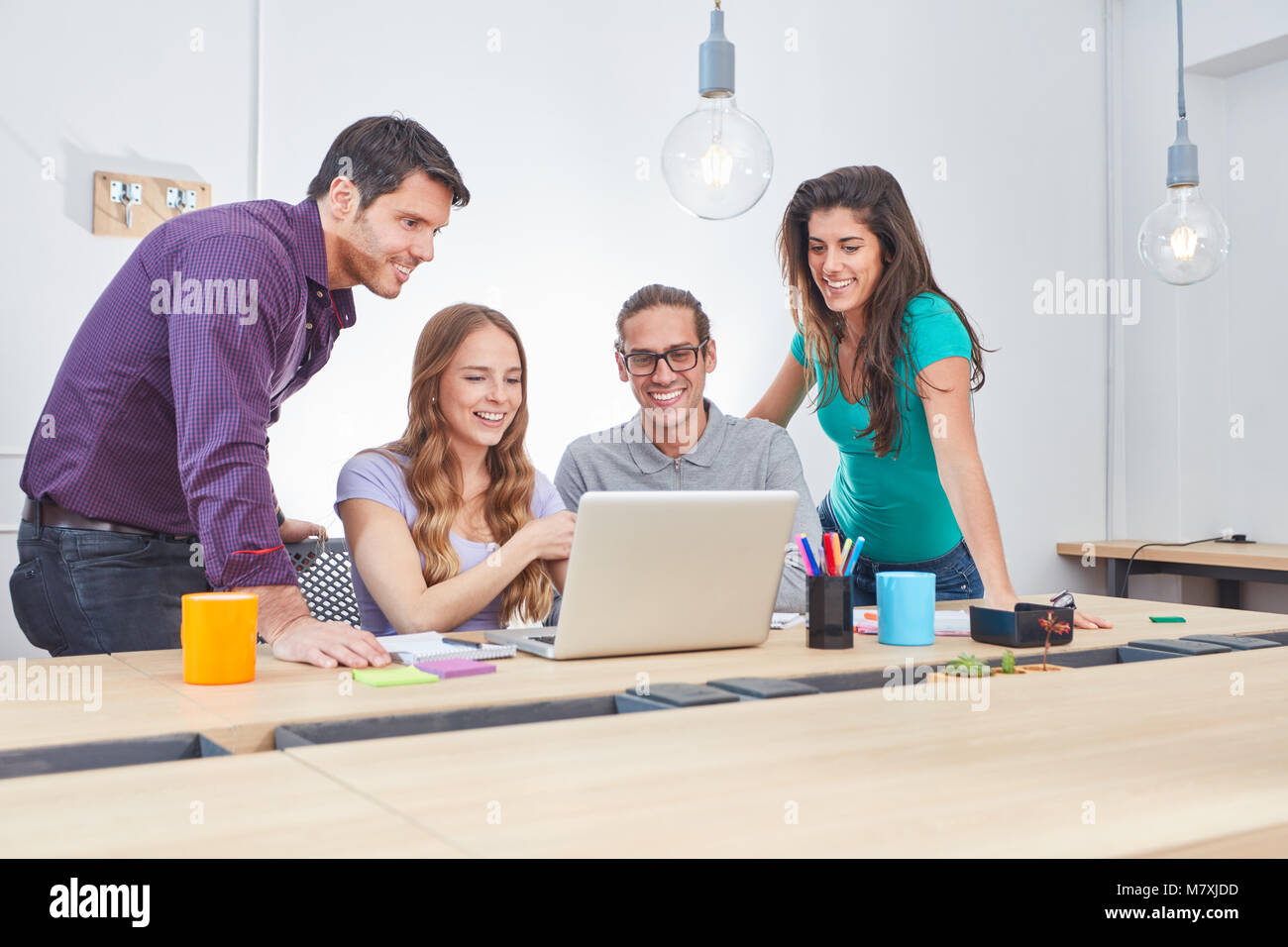 Group of students researching on laptop in computer workshop in office ...