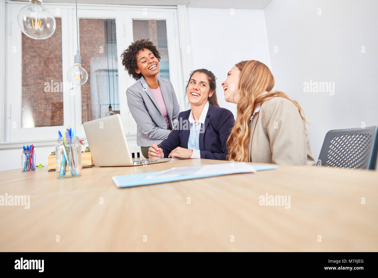 Three young business women in a meeting at the laptop computer are ...