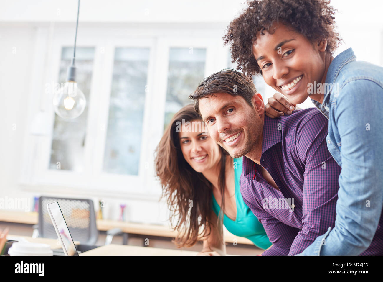 Three students as friends in the multicultural start-up team in the ...