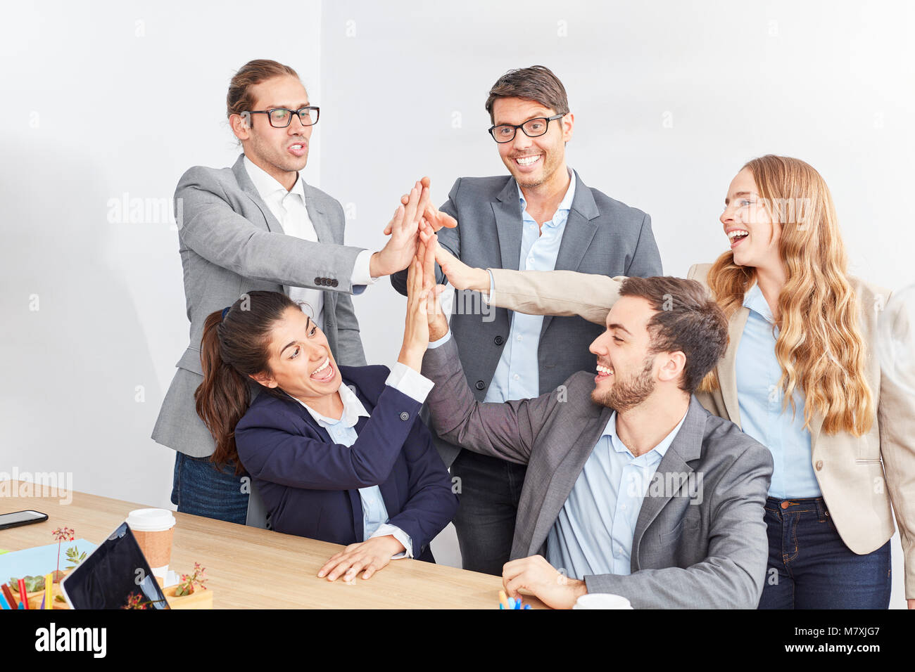 Colleagues in the start-up team give themselves the high five as a sign ...