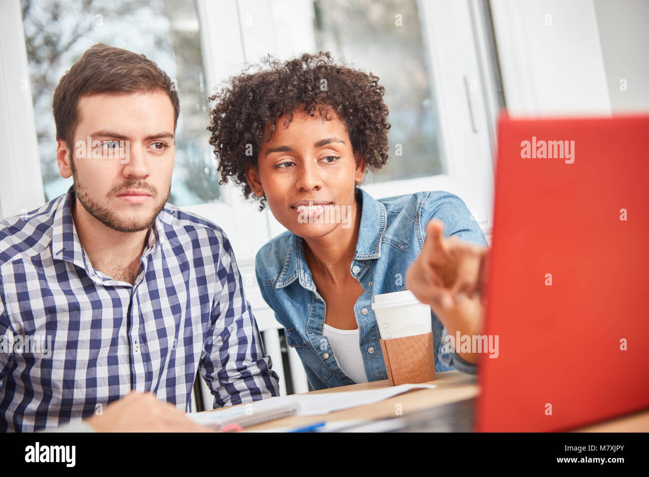 Two young business start-up colleagues are doing computer training ...