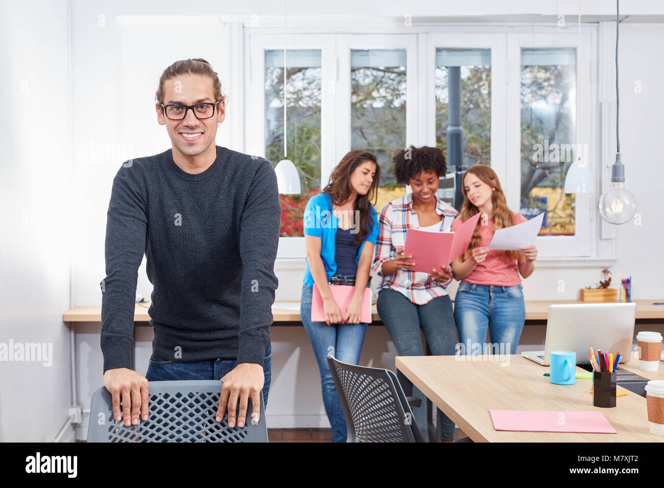 Young man as a successful entrepreneur in front of his start-up team ...