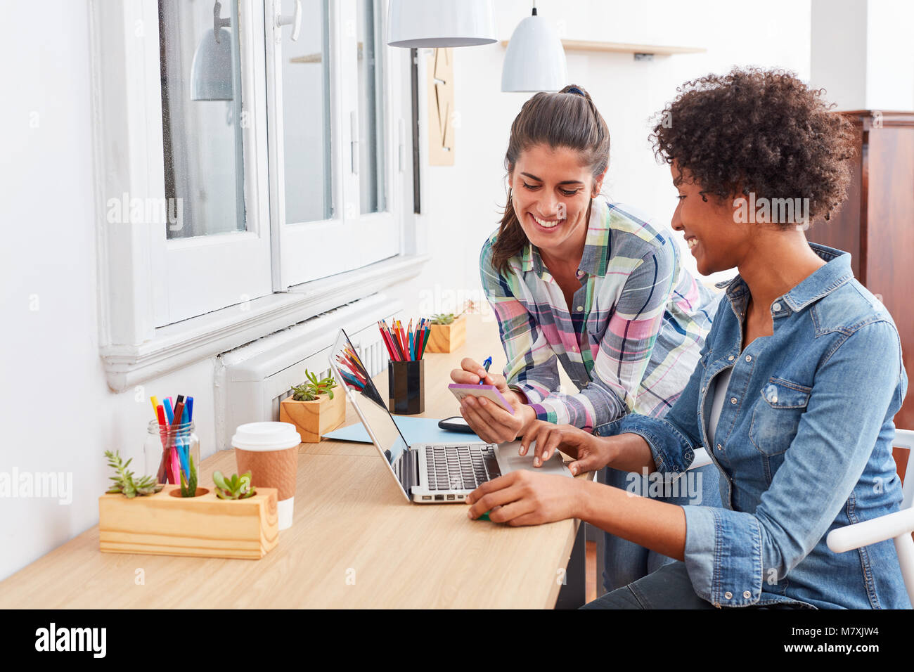 Two female students are learning together at the laptop computer in the ...