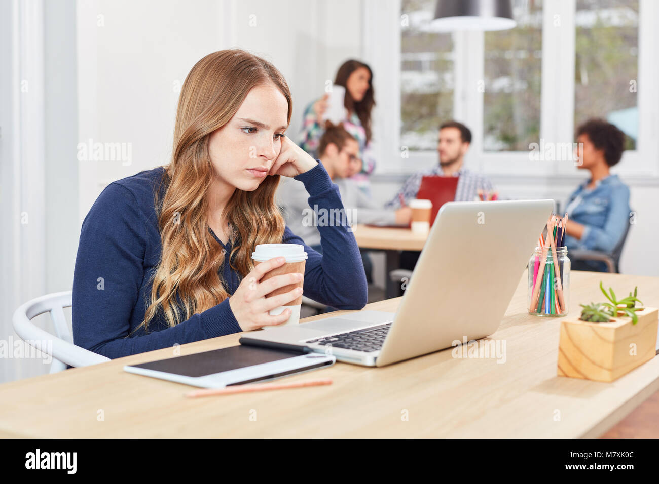 Young business woman reflects on a difficult problem after in coworking ...