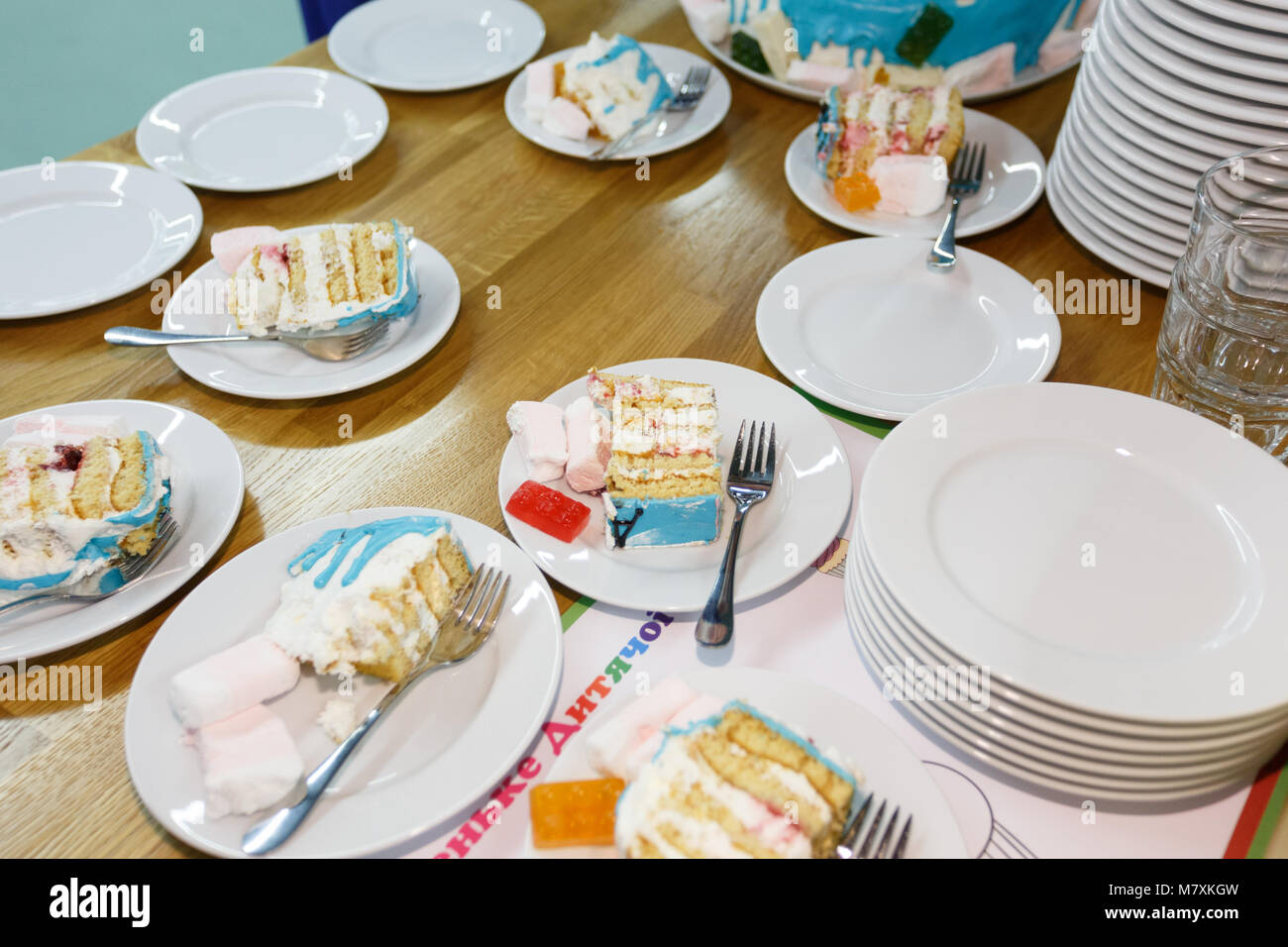 Childish birthday cake cut on the plates, top view Stock Photo - Alamy