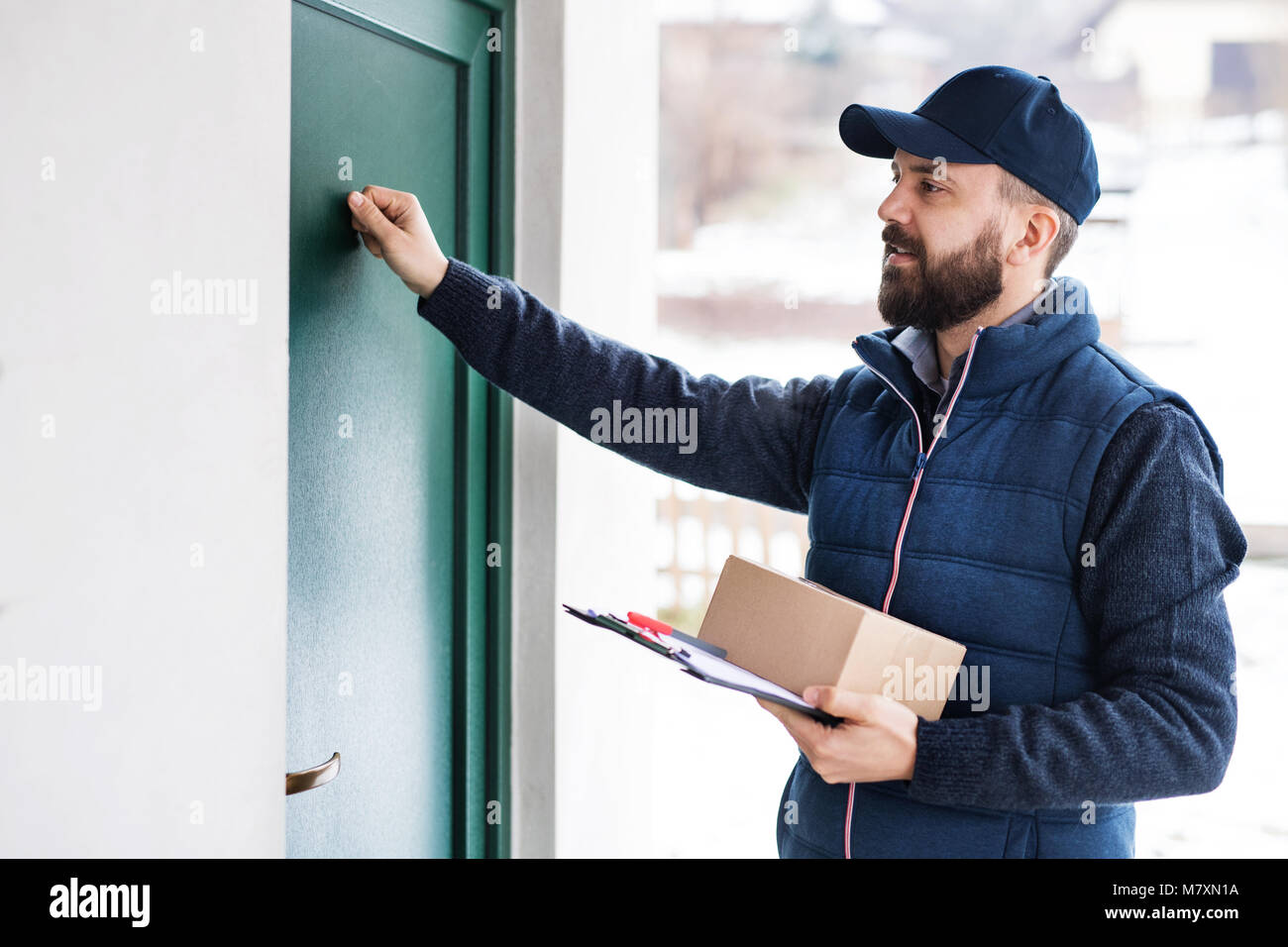 Delivery man delivering parcel box to recipient - courier service ...