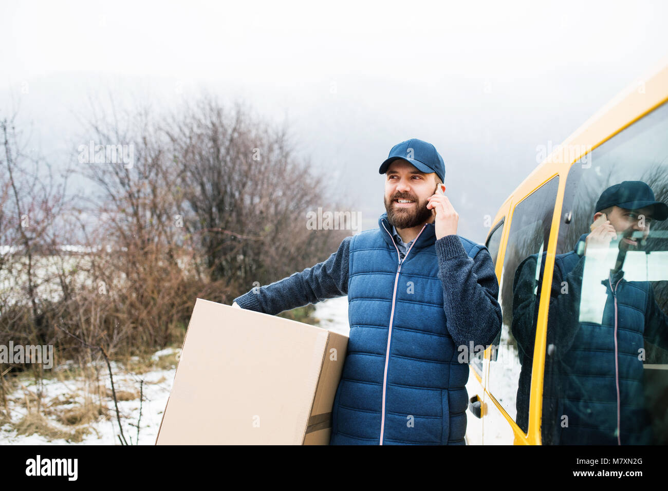 Delivery man delivering parcel box to recipient - courier service ...