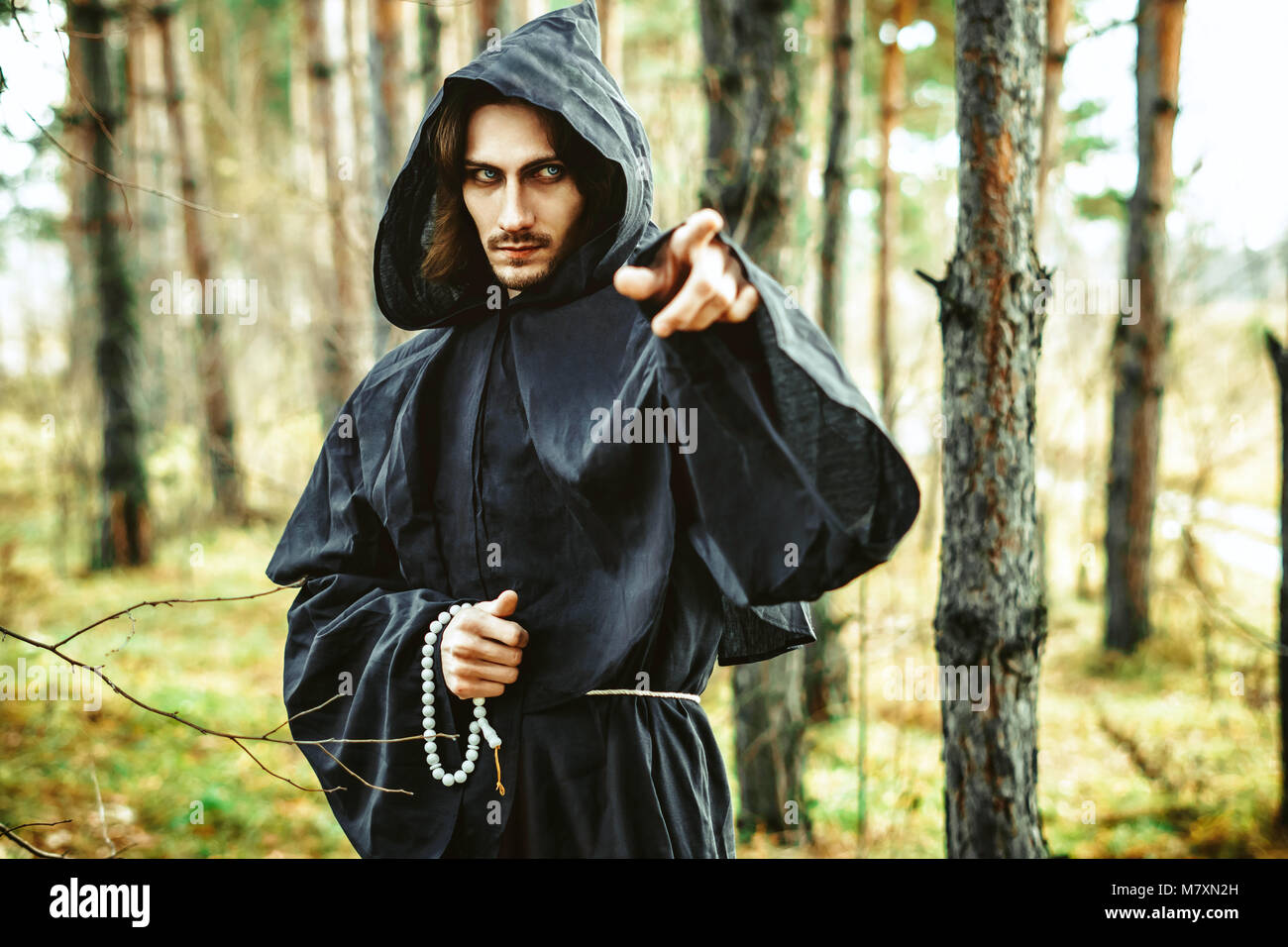 the black monk pointing his finger in the woods Stock Photo - Alamy