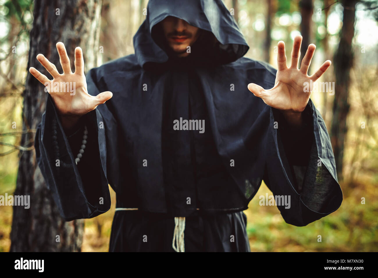 the black monk pointing his finger in the woods Stock Photo - Alamy