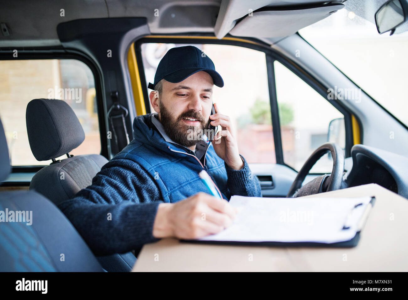 Delivery man delivering parcel box to recipient - courier service ...