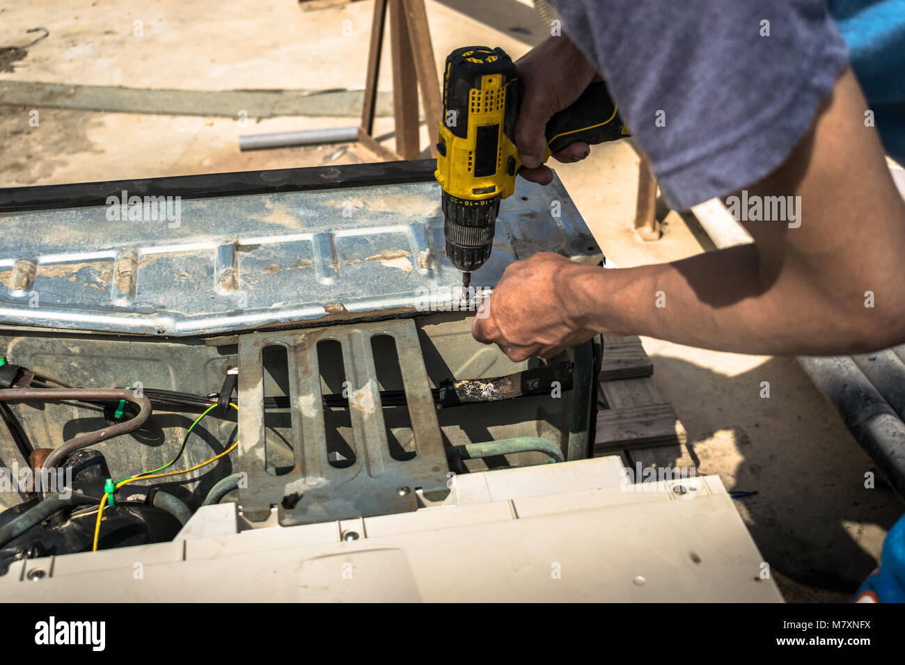 a professional electrician man is fixing the screw by auto screw driver ...