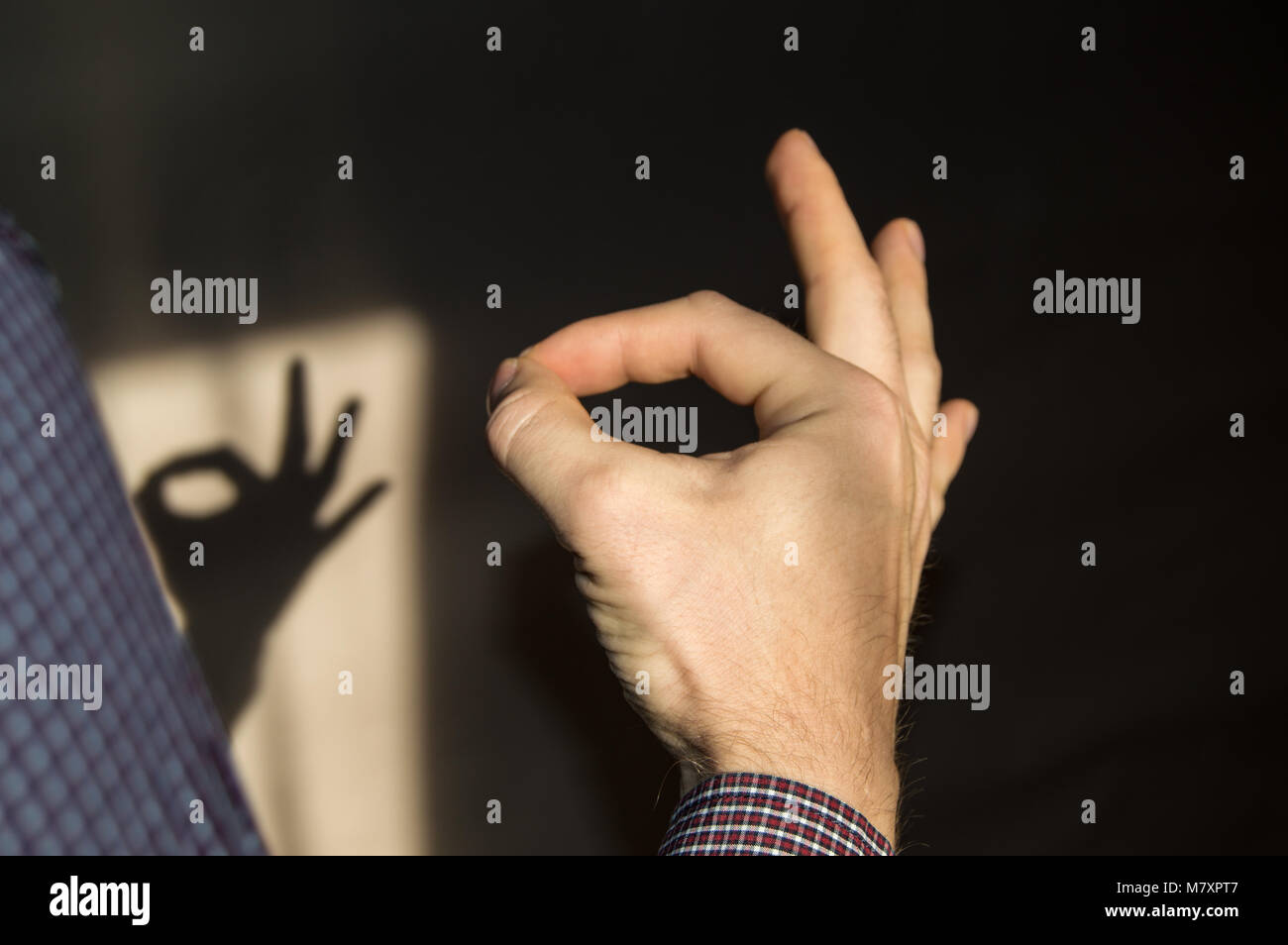 man gesturing OK sign on the wall the shadow of a hand Stock Photo - Alamy