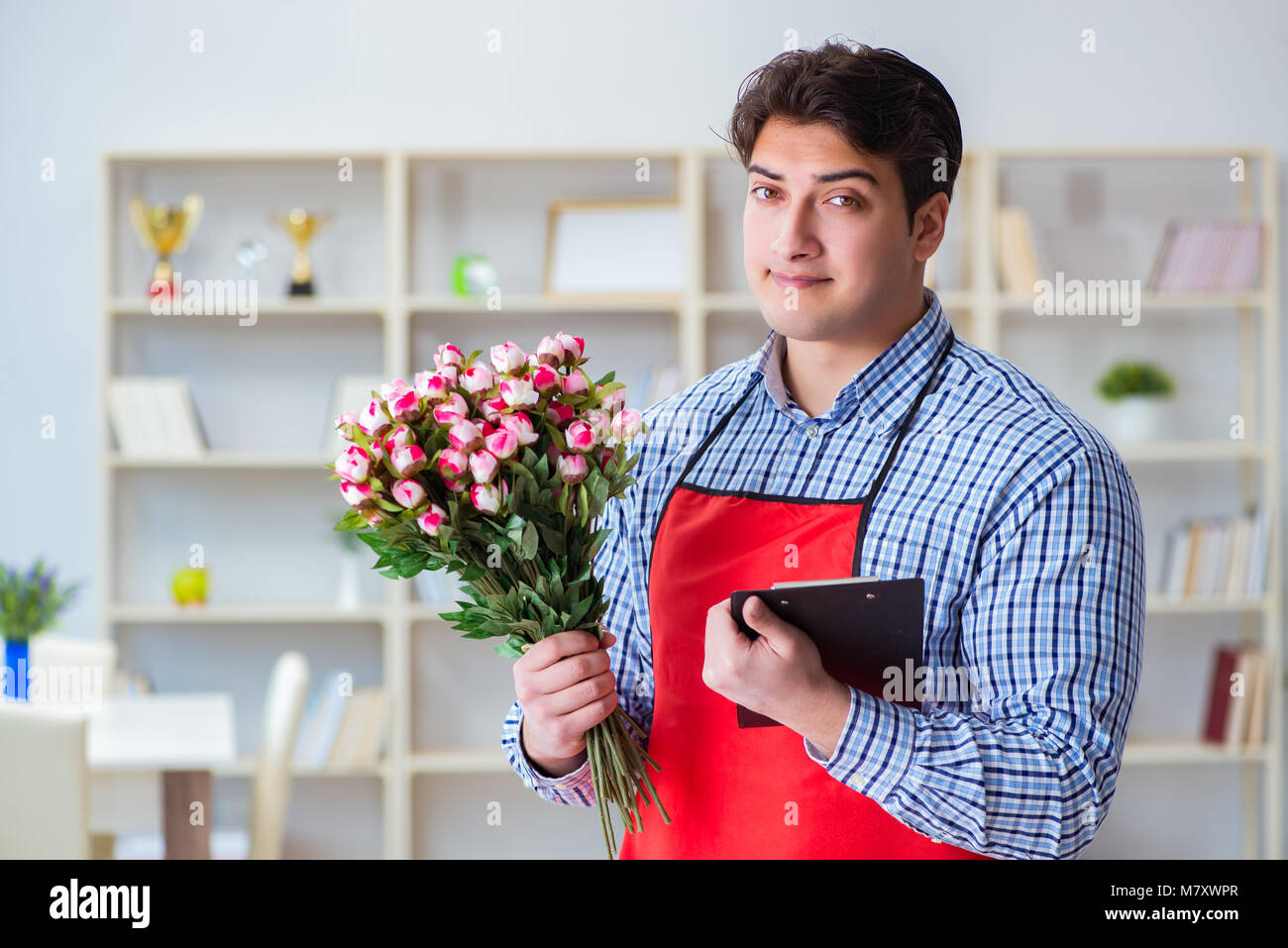 Flower shop assistant offering a bunch of flowers Stock Photo - Alamy
