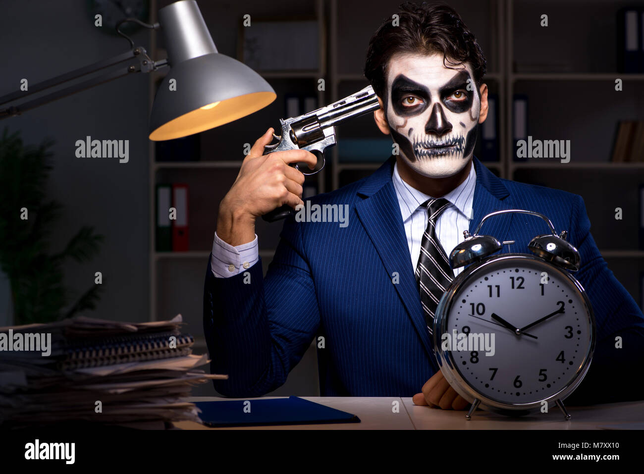 Businessman with scary face mask working late in office Stock Photo - Alamy