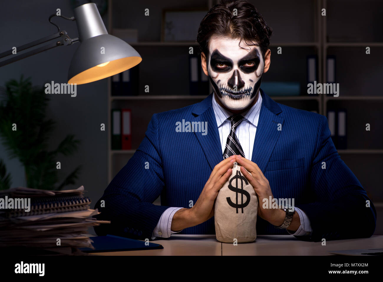 Businessman with scary face mask working late in office Stock Photo - Alamy