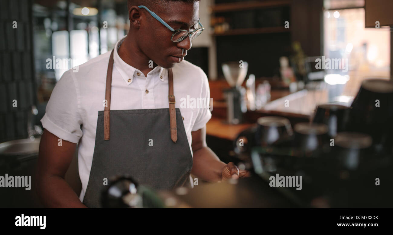 Coffee shop owner standing at the counter in his shop. Man working in ...