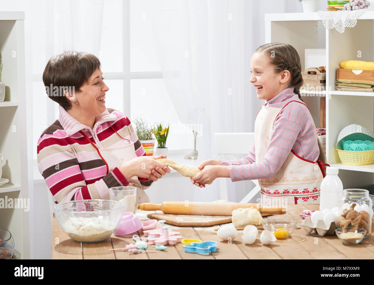 Mother and daughter cooking at home, making the dough for buns Stock ...