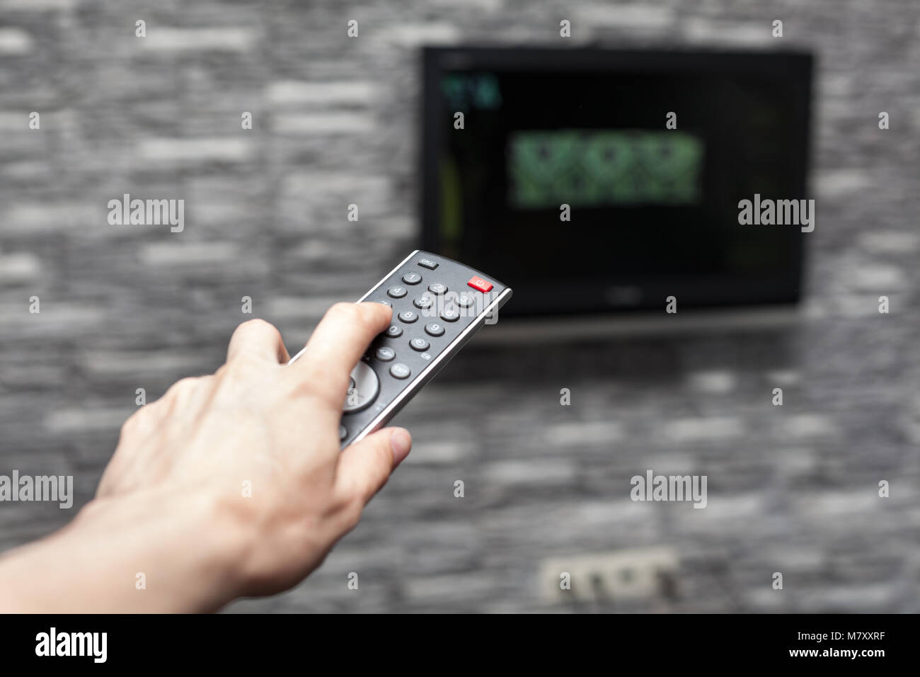 Female hand holding tv remote control and changing channel pushing a ...