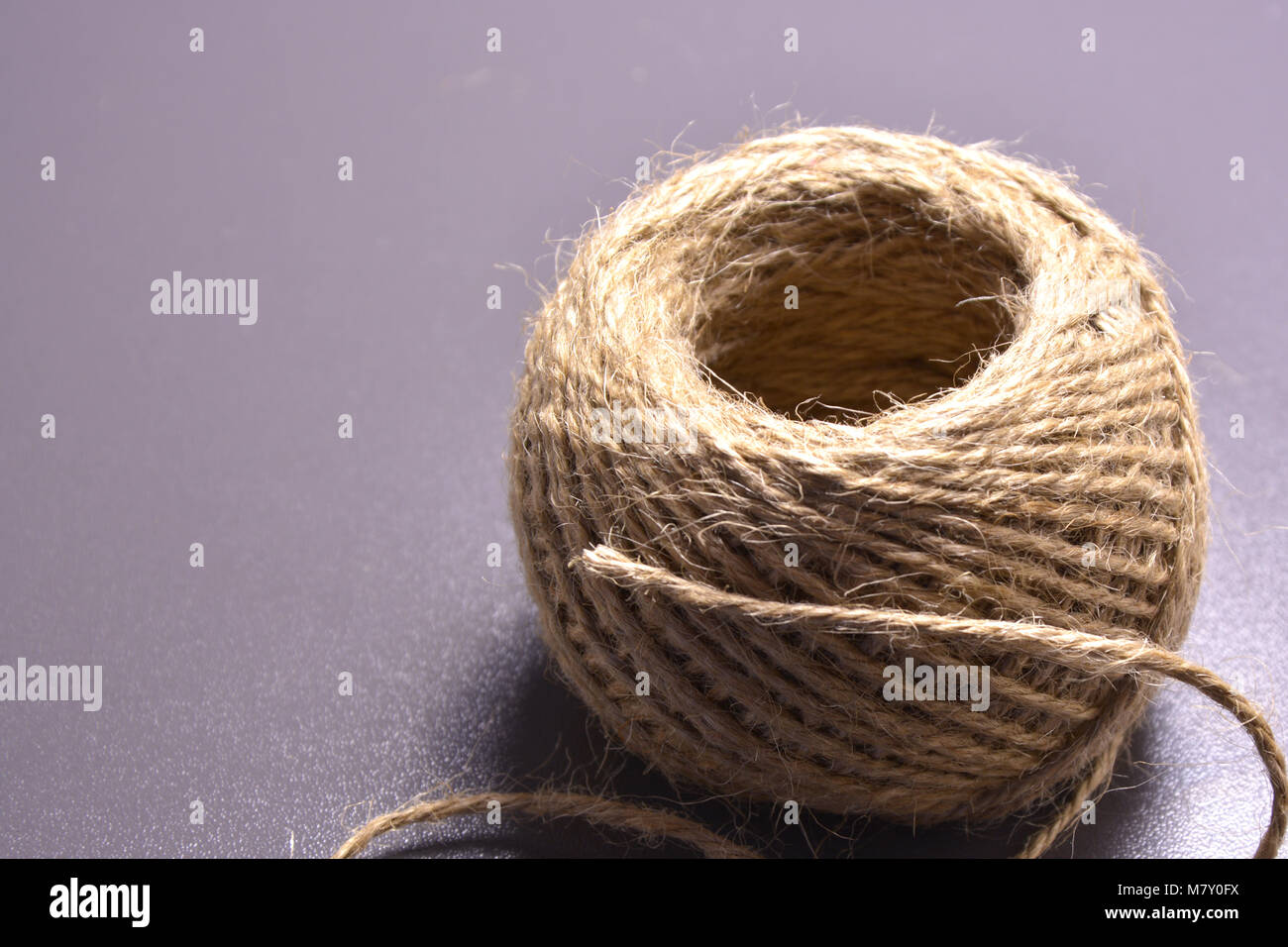 Jute string, roll rope on gray background Stock Photo - Alamy