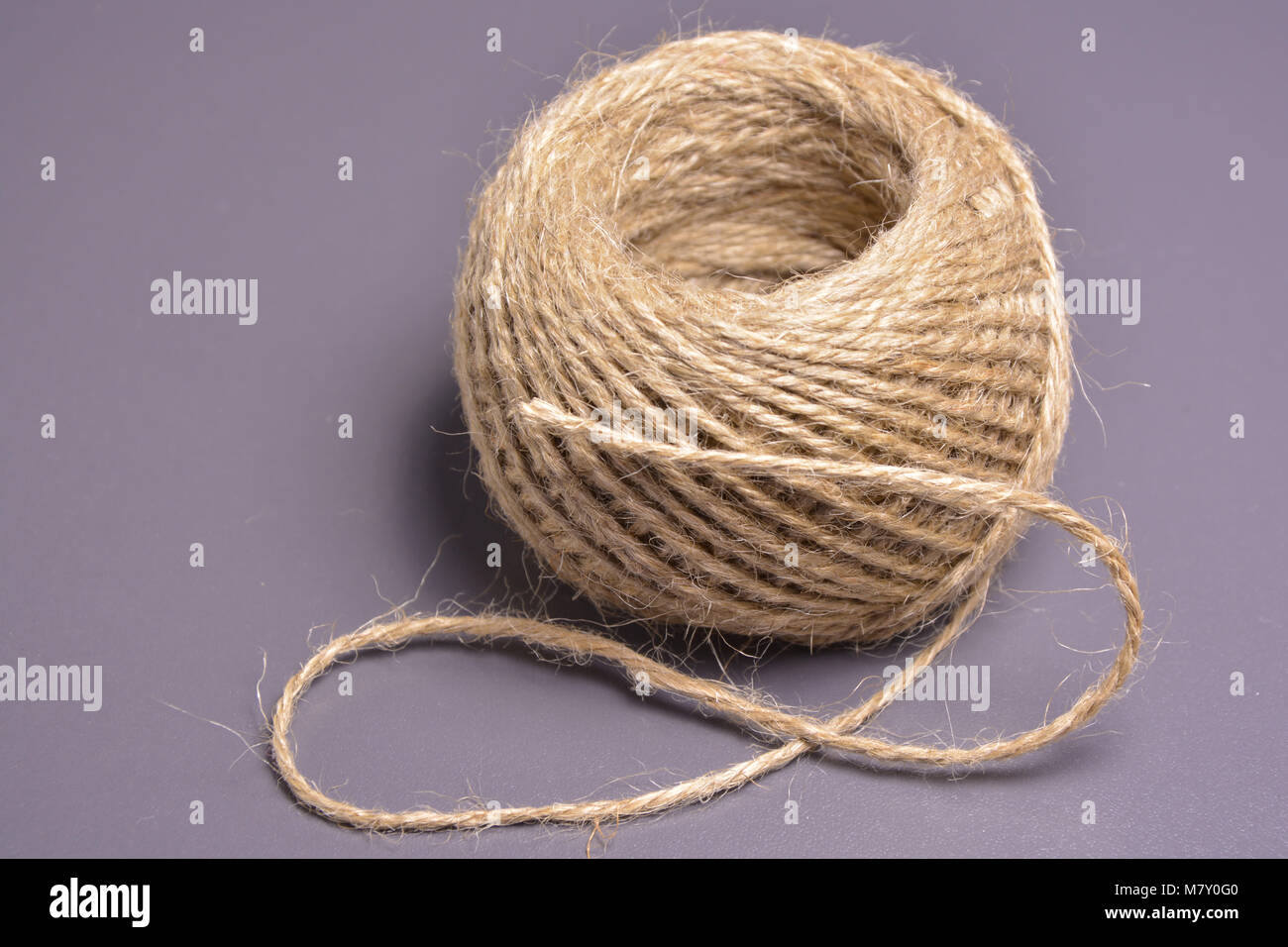 Jute string, roll rope on gray background Stock Photo - Alamy